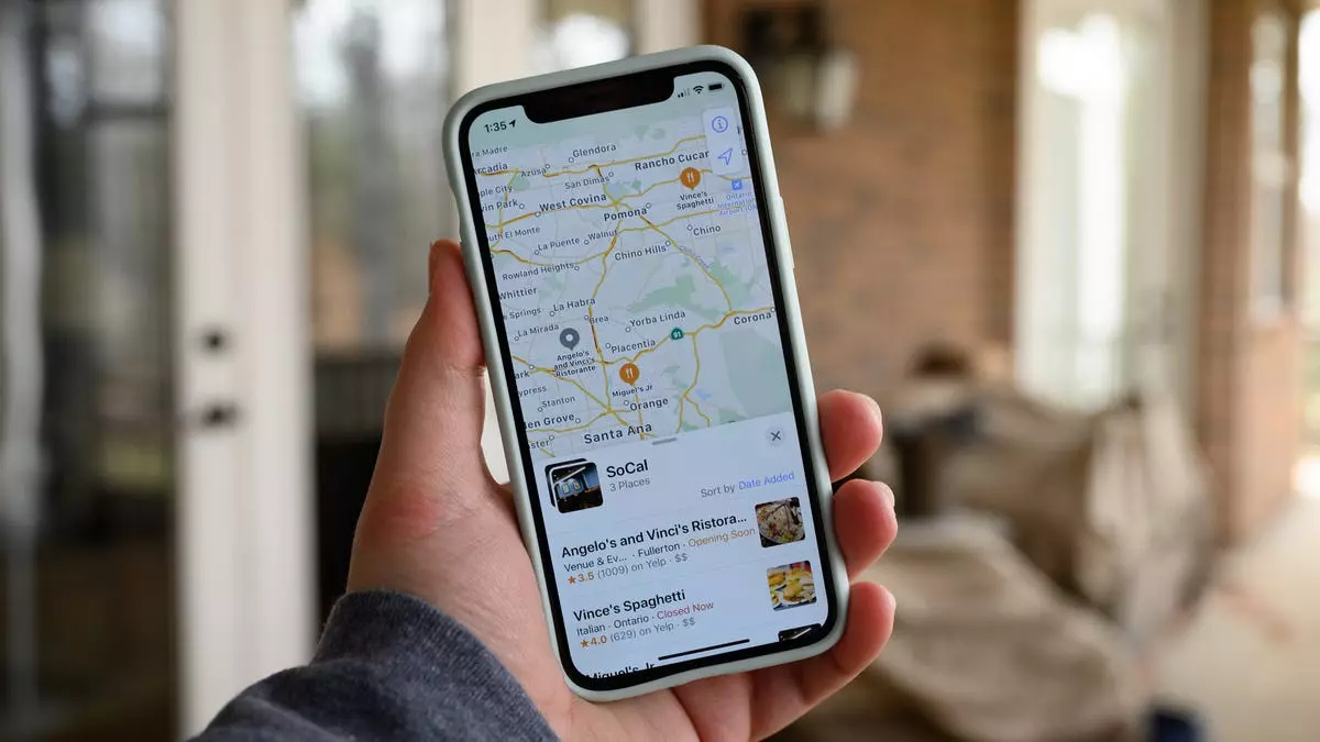 Apple Maps ಅಪ್ಲಿಕೇಶನ್ನ ಕ್ಲೋಸ್ಅಪ್ನೊಂದಿಗೆ ಯಾರೋ ಐಫೋನ್ ಅನ್ನು ಹಿಡಿದಿದ್ದಾರೆ.