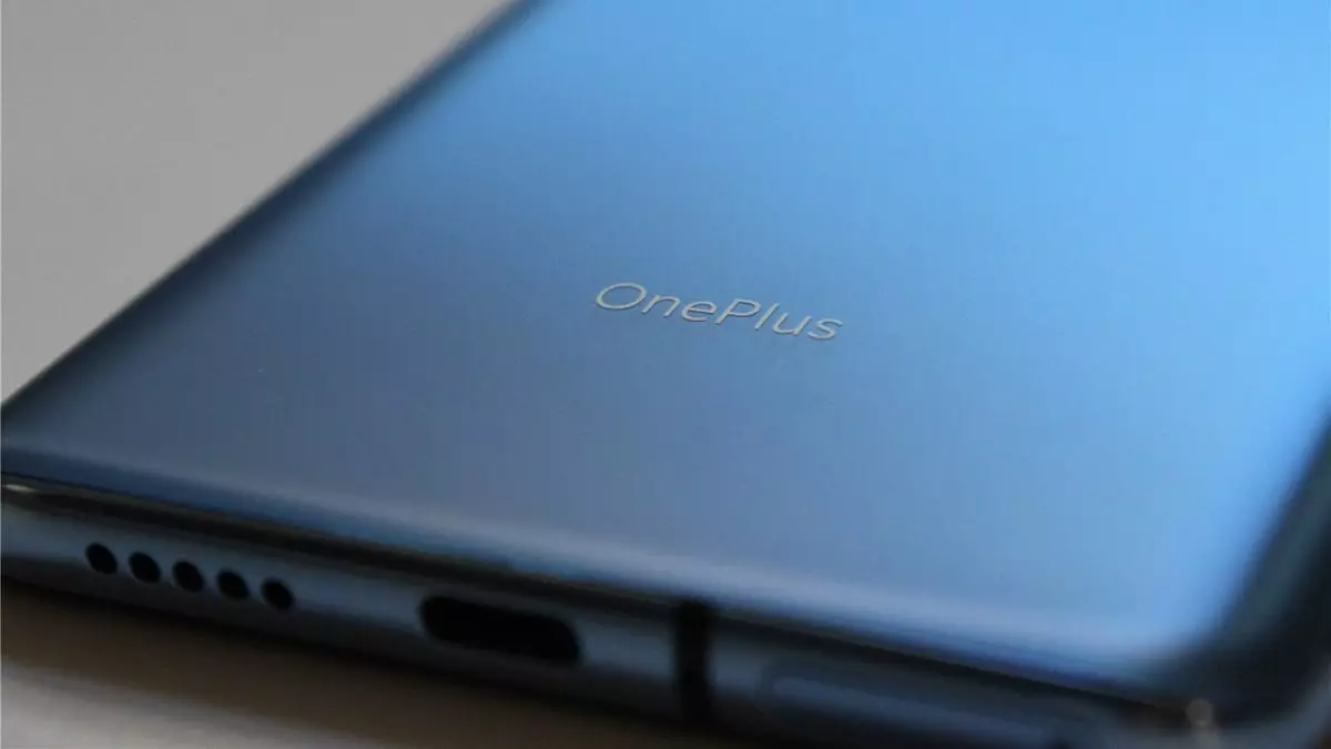 Dèyè yon OnePlus 7T, ki montre logo la ak pò USB-C.