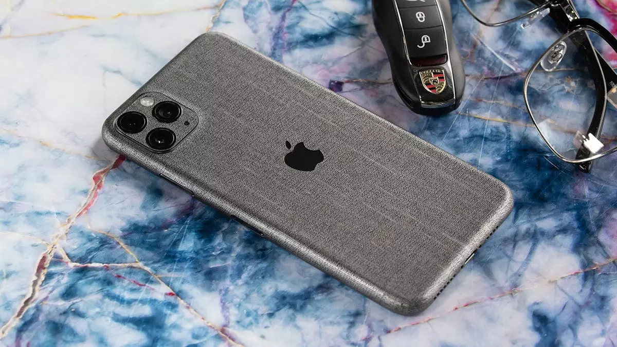 Ein iPhone, das mit einer grauen SlickWraps-Haut bedeckt ist.