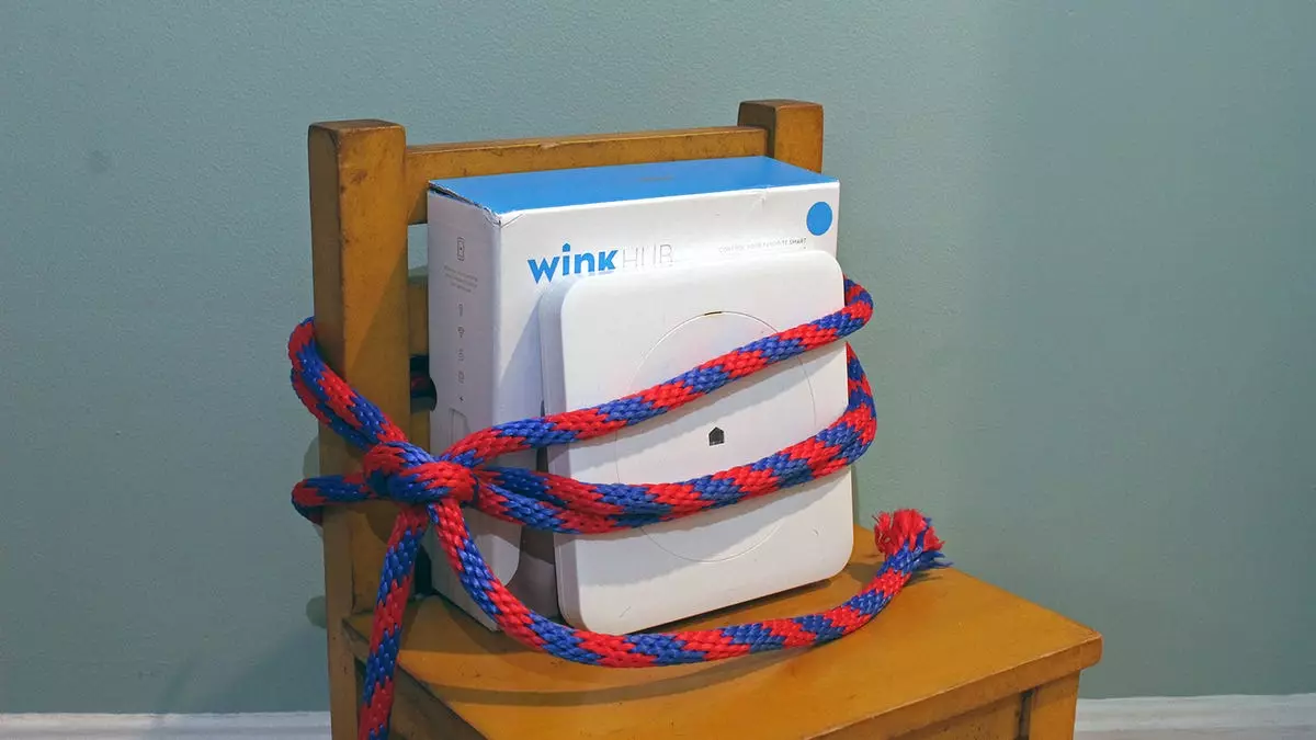 Wink Hub in škatla, privezana na stol, kot bi bila odkupljena.