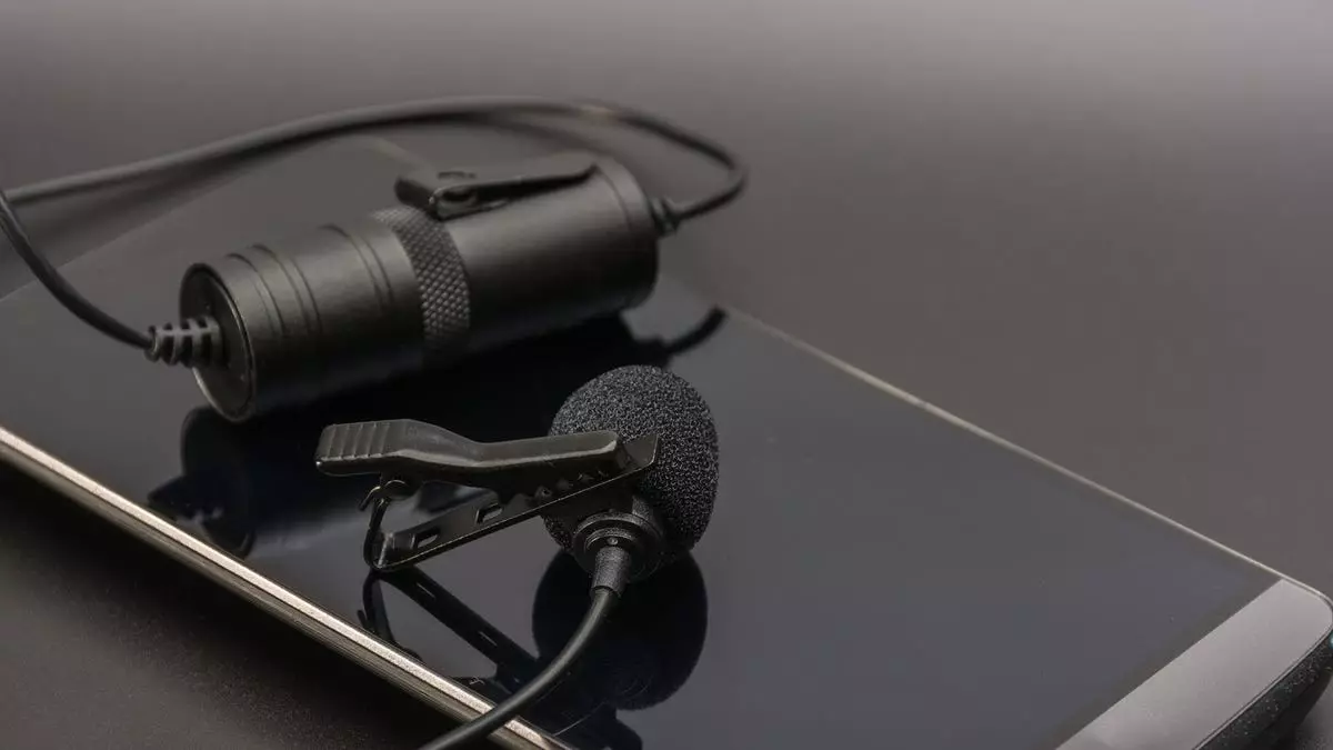 Um microfone de lapela apoiado em um smartphone.
