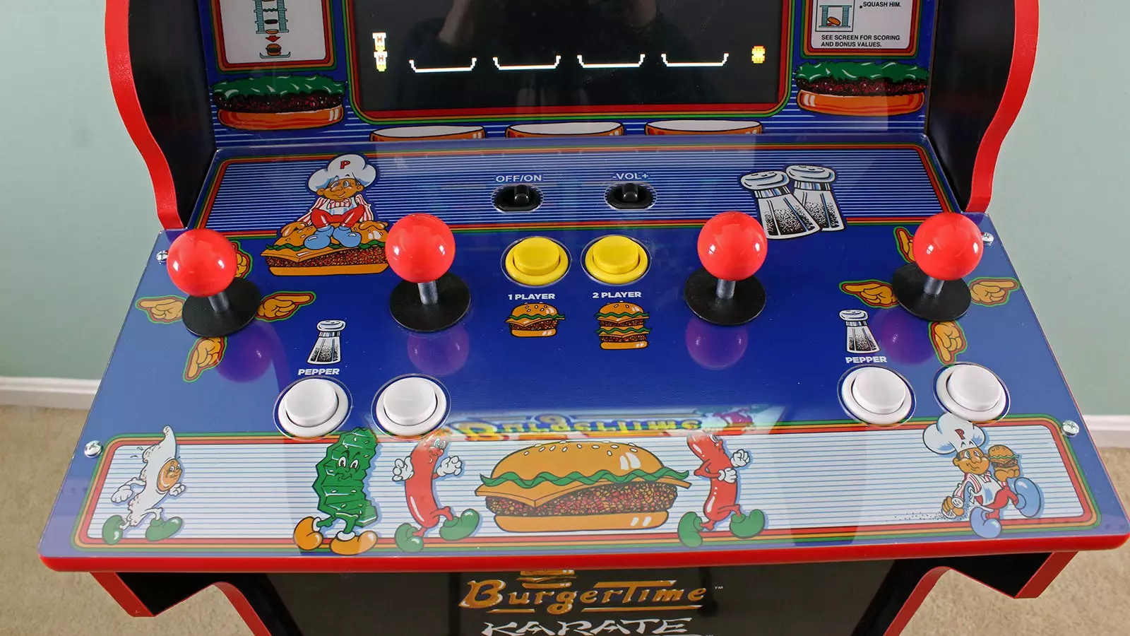 Um close do deck de controle mostrando as mãos direcionais ao redor do primeiro e do quarto joystick.
