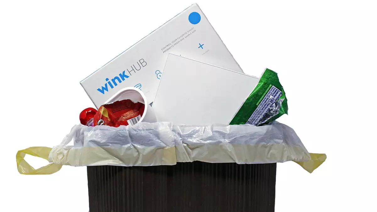 Ένα Wink Hub and Box σε έναν κάδο απορριμμάτων με άλλα σκουπίδια.