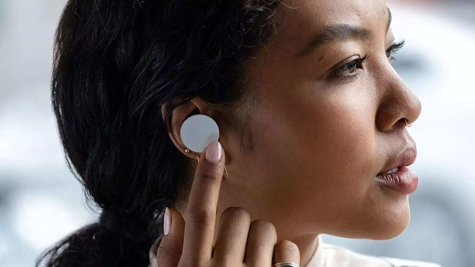 Một người phụ nữ đeo tai nghe Surface Earbuds