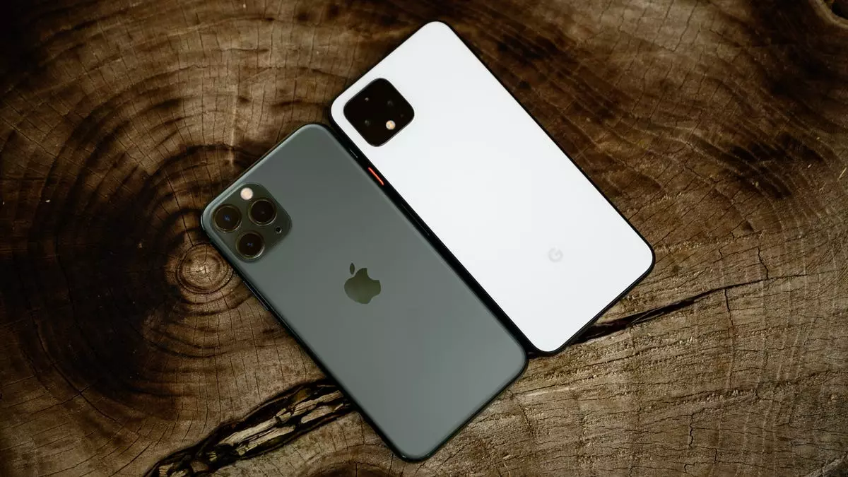 Một chiếc iPhone của Apple bên cạnh một chiếc Google Pixel trên băng ghế gỗ.