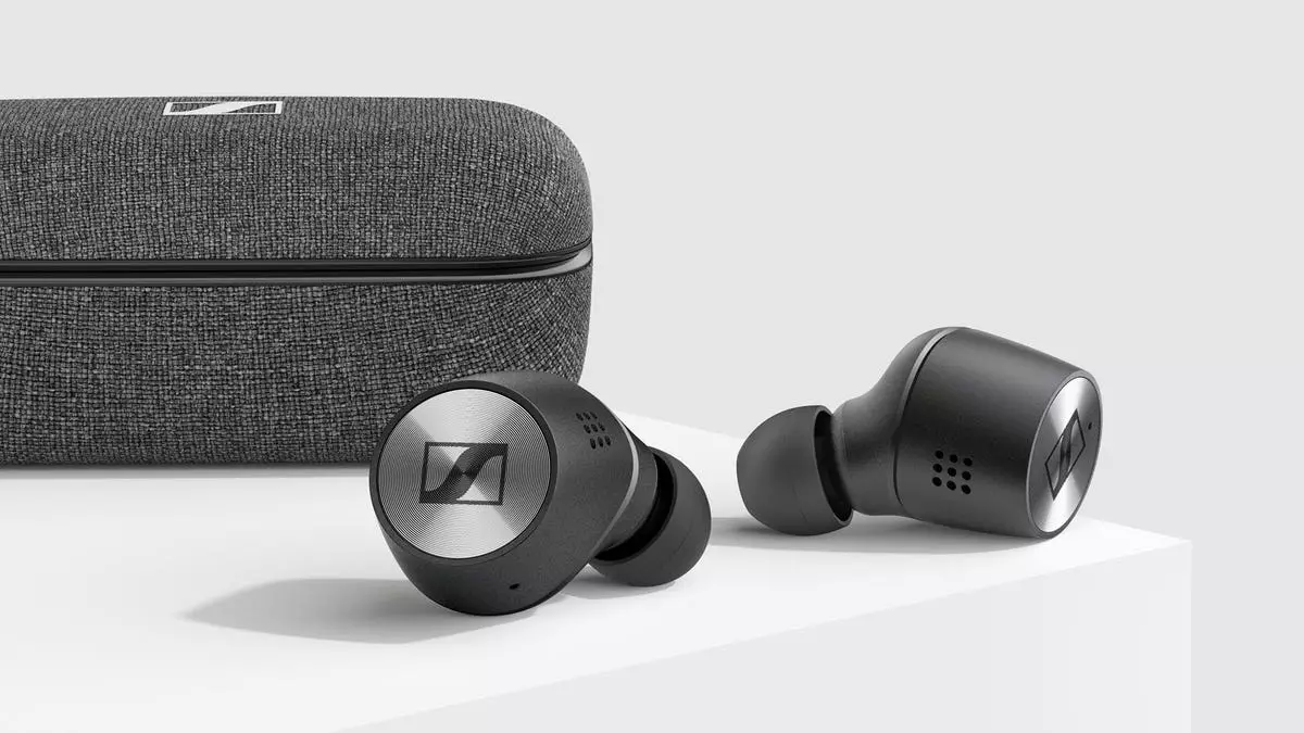 Ein Paar graue Sennheiser Momentum True Wireless Ohrhörer neben einem grauen Stoffetui.
