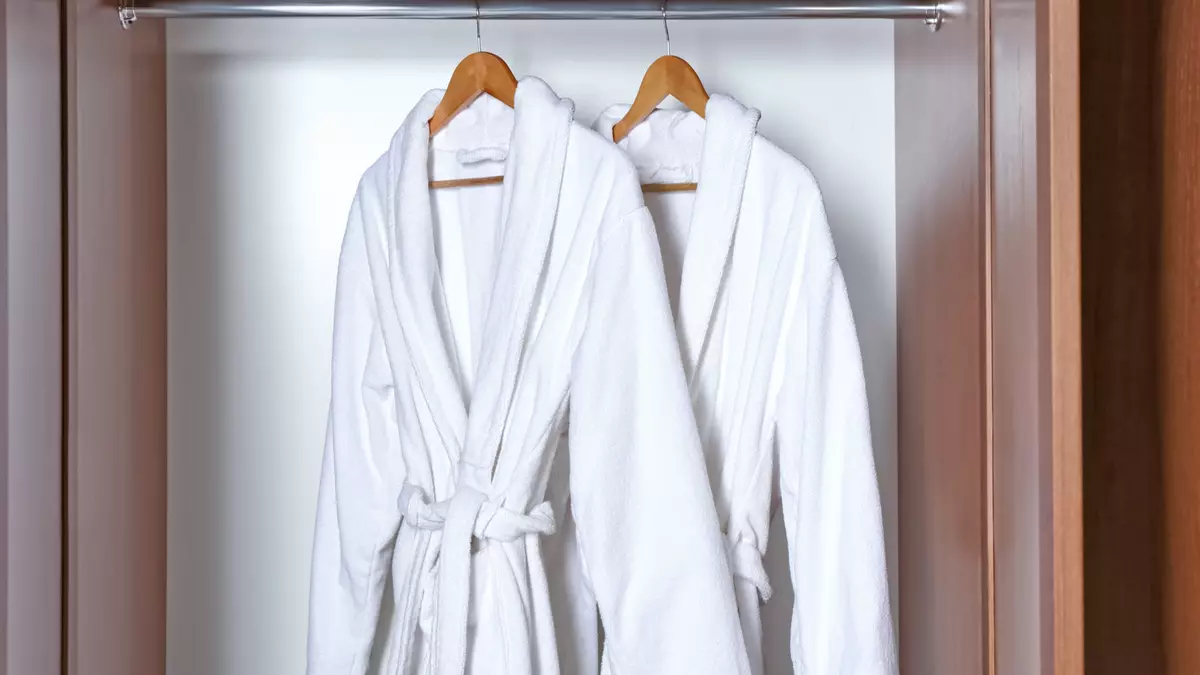 Dues bates de bany blanques penjades en un armari