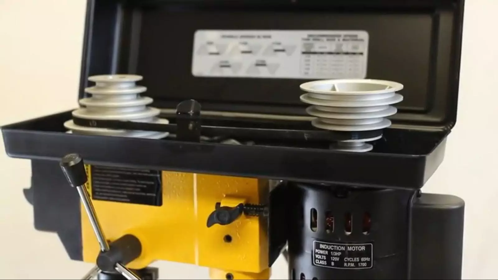 Usa ka pulley ug band system sa ibabaw sa drill press.