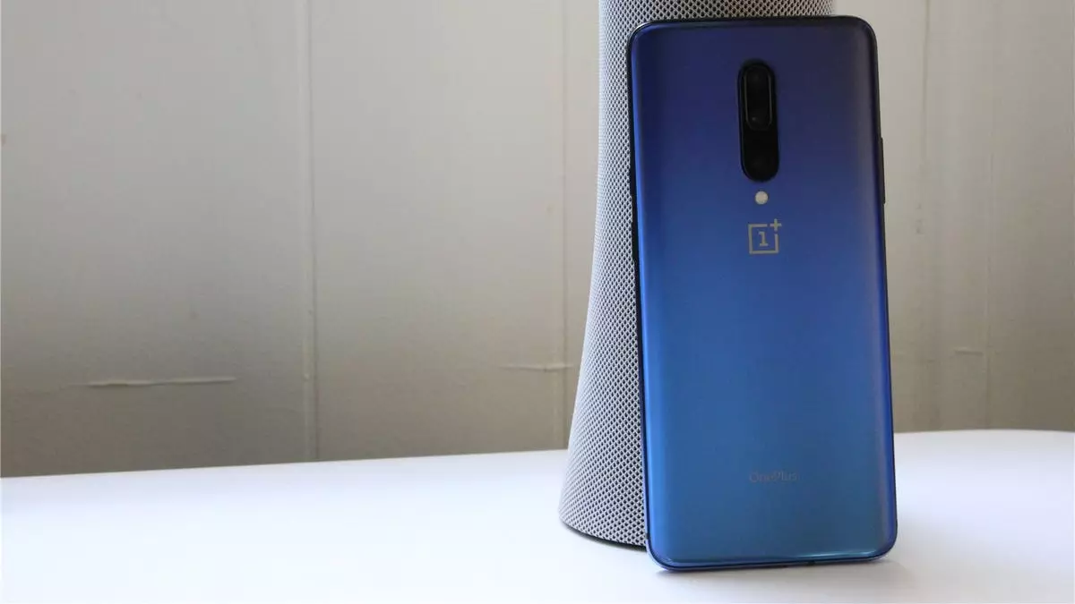Un teléfono OnePlus 7 Pro azul apoyado contra un altavoz inteligente.
