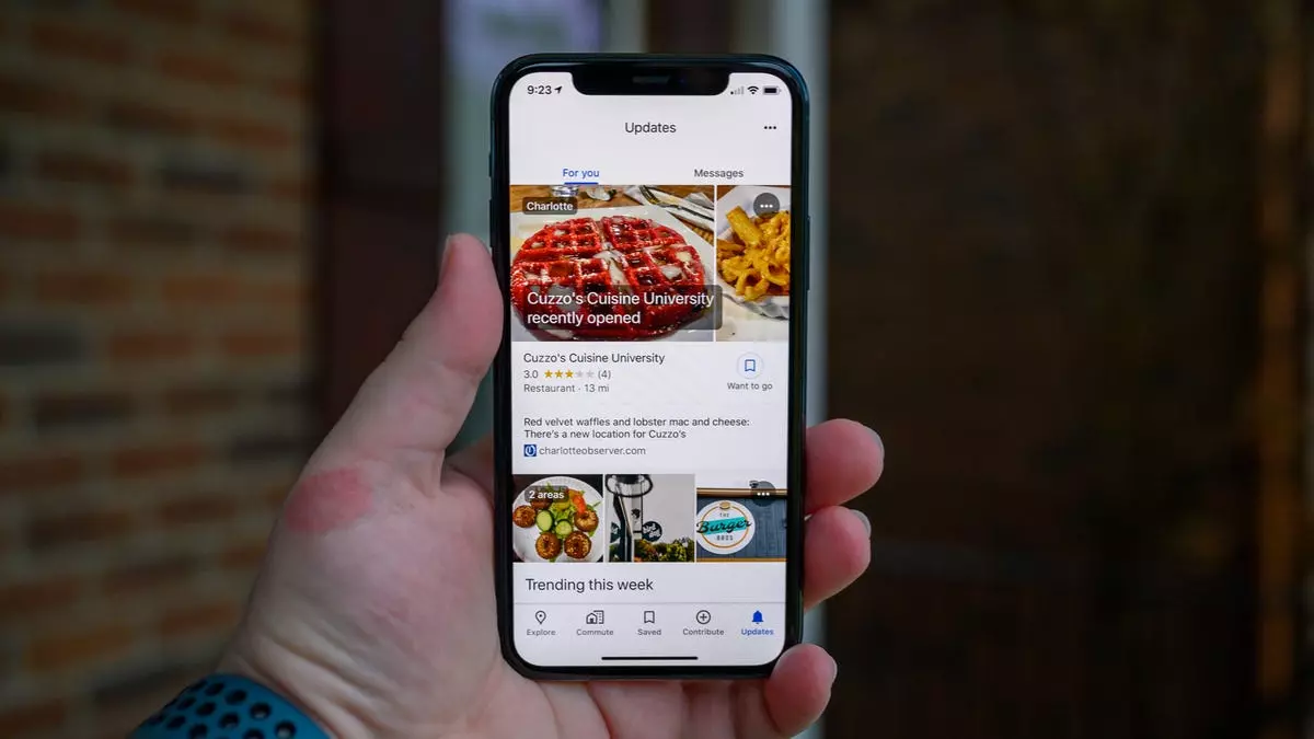 Một chiếc iPhone có tab Cập nhật Google Maps mới hiển thị một nhà hàng địa phương mới mở.