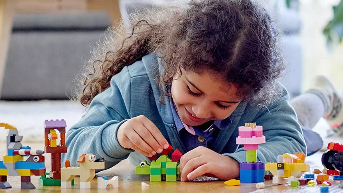Seorang gadis muda bermain dengan batu bata LEGO.