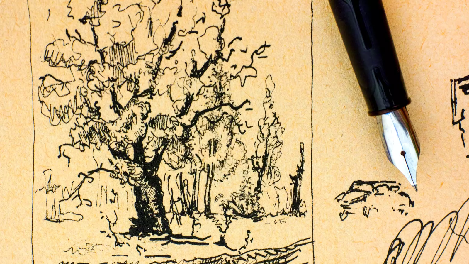 Un stilou întins pe un desen cu cerneală a unui copac.