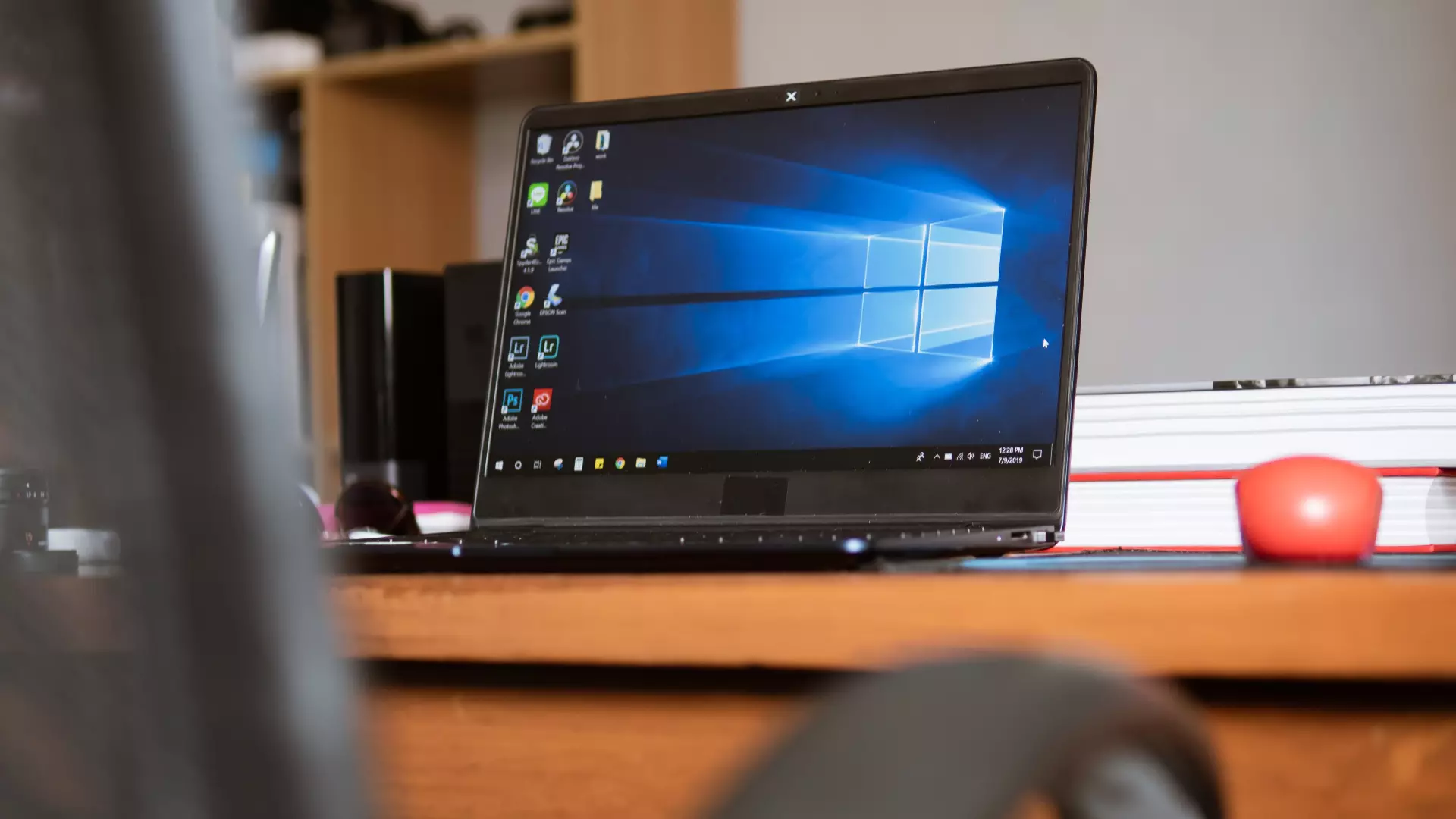 Kannettava tietokone, jonka näyttö näkyy Microsoft Windows -logolla työpöydällä.