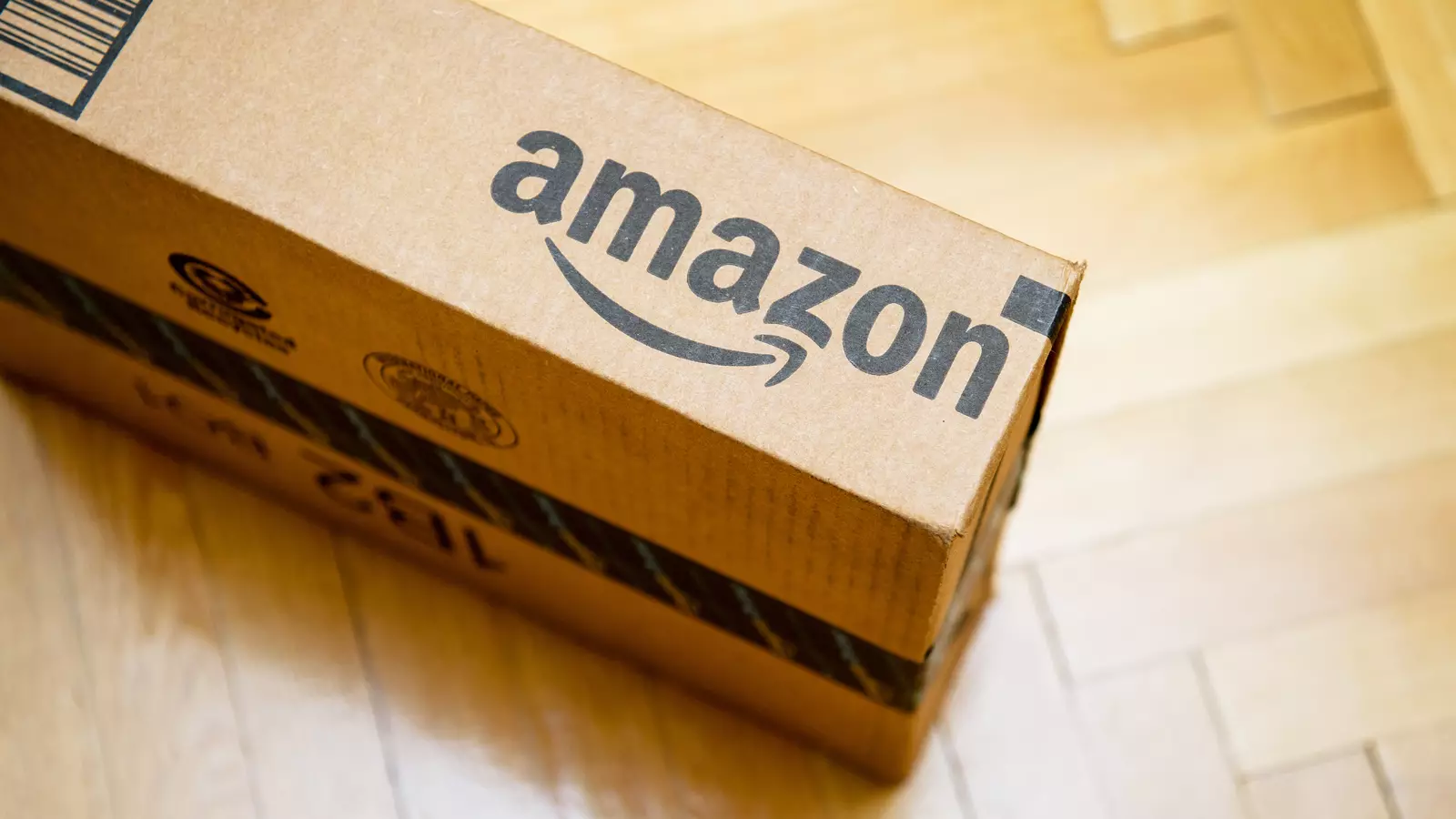 Một chiếc hộp Amazon đặt trên sàn gỗ cứng.