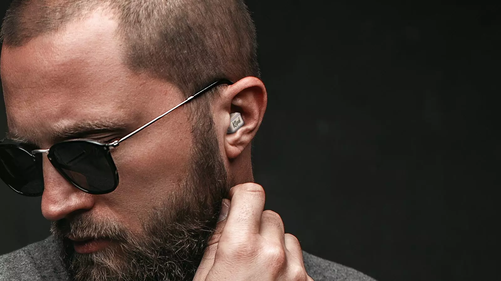 Một người đàn ông đeo tai nghe không dây T10 True Wireless mới nhét gần vào tai.