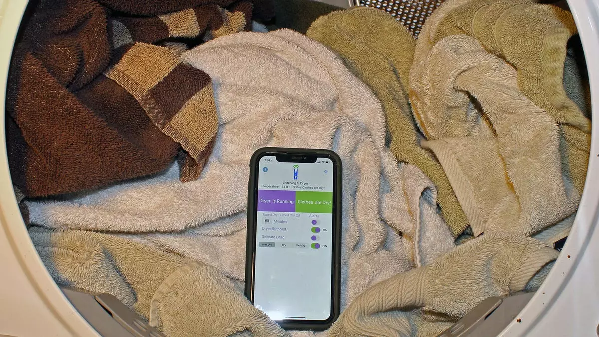 Die SmartDry-App auf einem Telefon, das sich in einem Trockner voller Handtücher befindet.