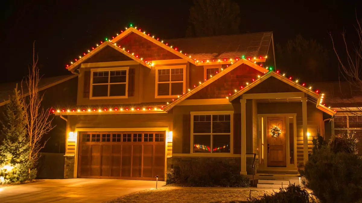 Božične lučke na zunanjosti dvonadstropne hiše.