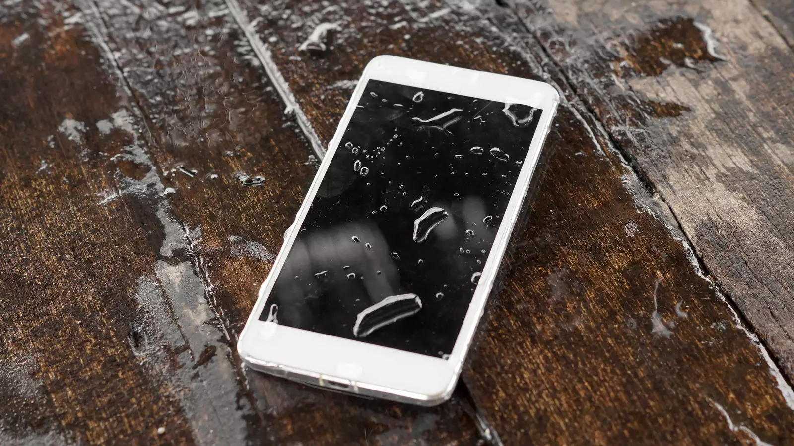Smartphone i lagur në tavolinë prej druri