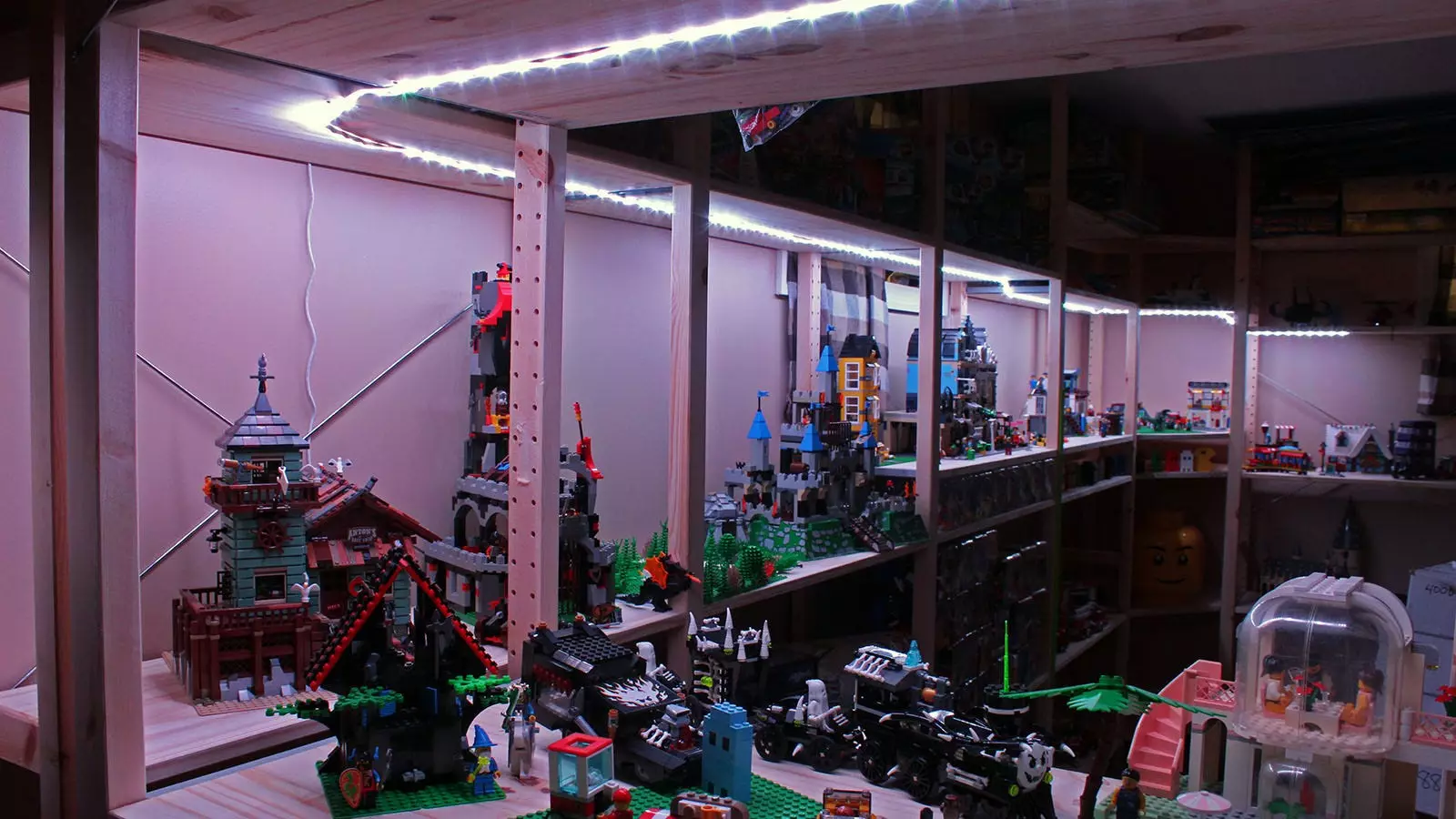 Lego kerpiçleri bilen doldurylan garaňky otagy yşyklandyrýan ak yşyk-diodly uzyn zolak.