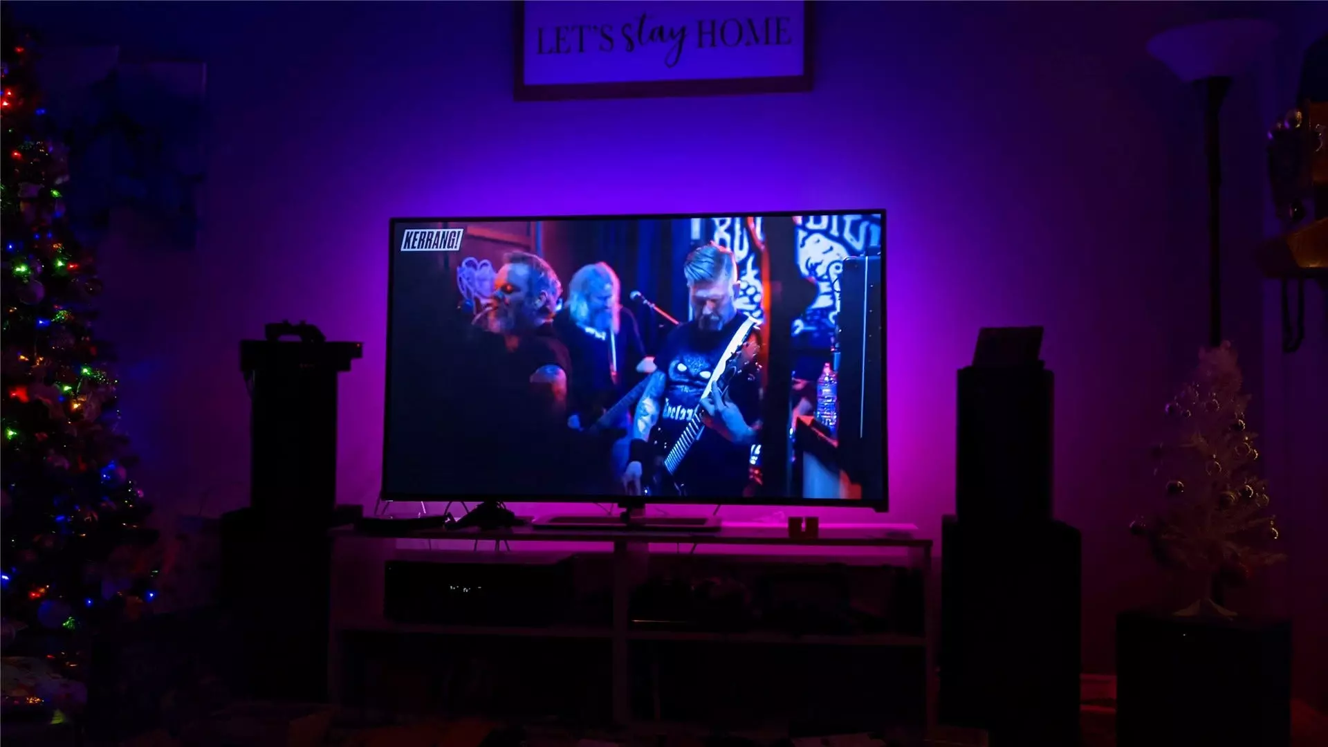 The Immersion si illumina di blu, viola e rosa dietro una TV che trasmette un concerto dal vivo