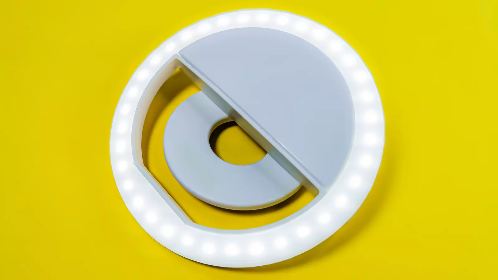 Close-up na LED selfie circular ring light lamp para sa camera phone laban sa maliwanag na dilaw na background