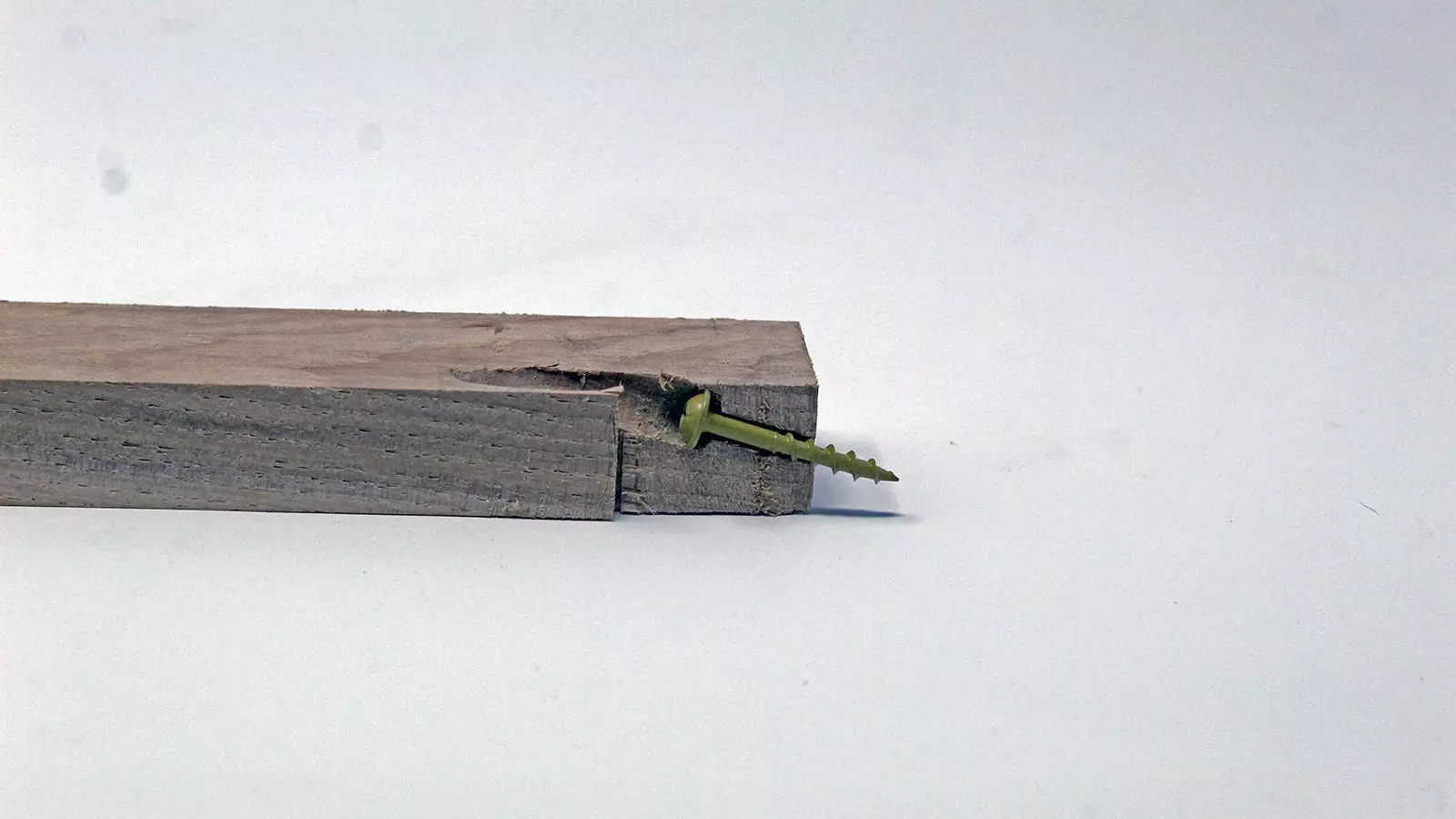 Une planche de bois avec le bord coupé, révélant l'intérieur d'un trou de poche.
