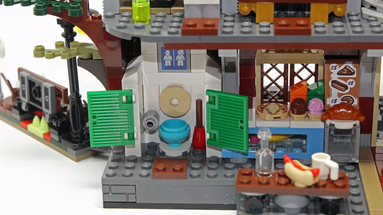 प्लंजर और टॉयलेट पेपर सहित एक छोटा लेगो बाथरूम।