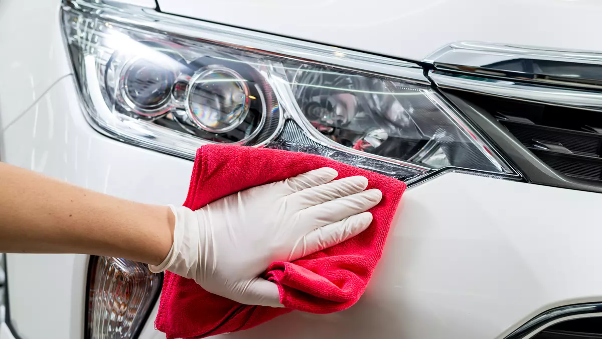 Ένα χέρι που σκουπίζει το εξωτερικό ενός αυτοκινήτου.