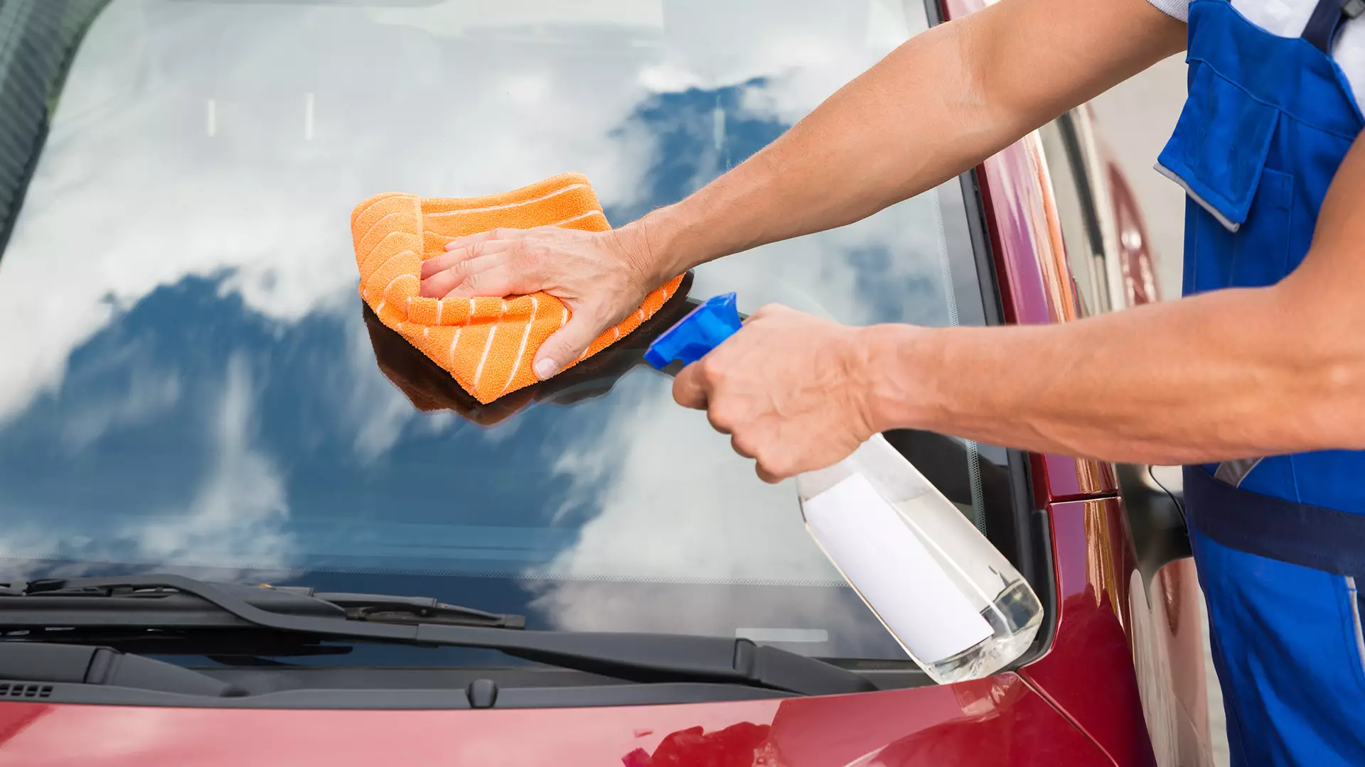 En person som rengör sin bils vindruta.