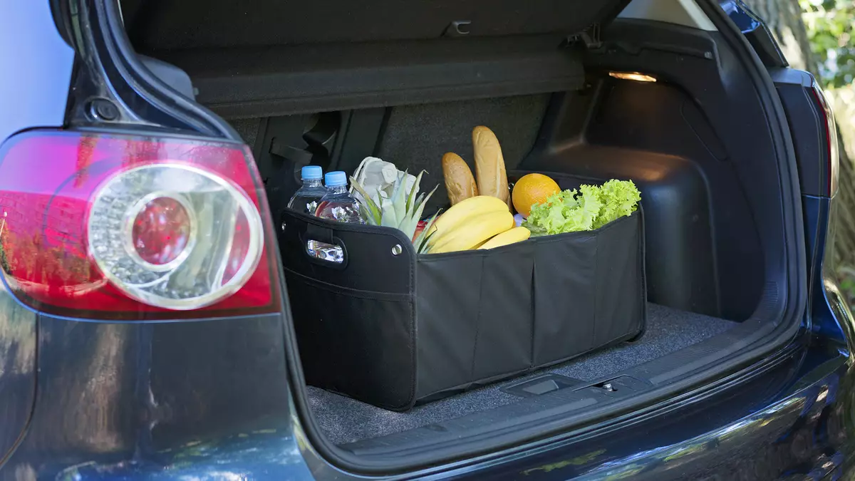 سازماندهی صندوق عقب مشکی پر از مواد غذایی در یک صندوق عقب.