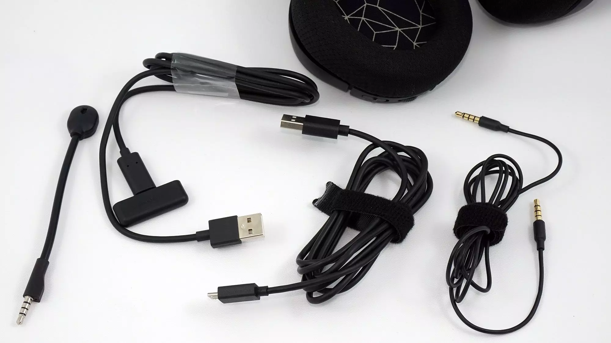 Boom nan mikwofòn, dongle USB-C, kòd chaje MicroUSB, adaptè USB-A-a-fi-C, ak kab kas ekoutè estanda.