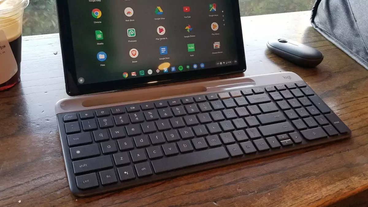 Το πληκτρολόγιο Logitech K580 κάθεται σε ένα τραπέζι μπροστά από ένα tablet Chrome OS.