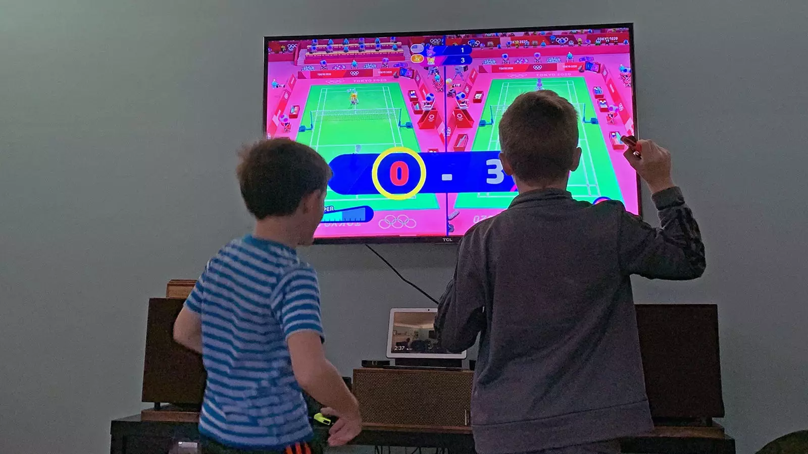 Du jauni berniukai žaidžia tenisą per „Nintendo Switch“.
