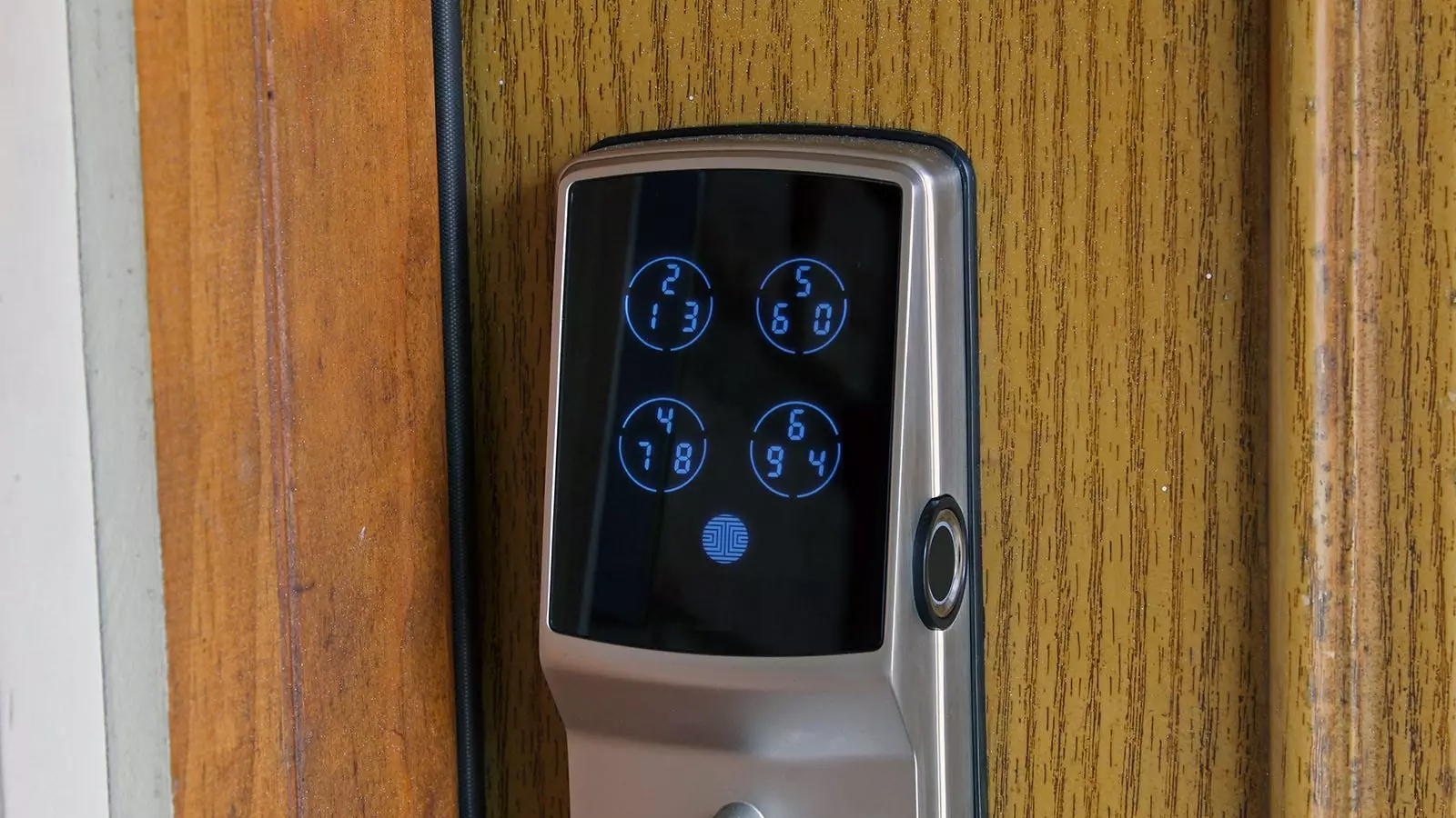Bližnji posnetek ključavnice Lockly Secure Pro, ki prikazuje štiri kroge, polne številk.