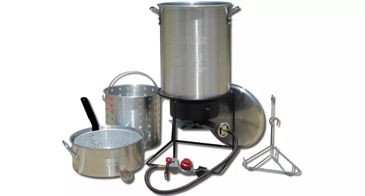 King Kooker 丙烷油炸锅放在燃烧器上，靠近盖子、篮子、吊钩和带篮子的煎锅