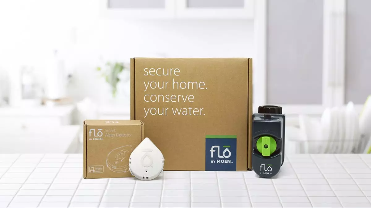 Un sensor Flo Smart Water al costat d'un monitor d'aigua Flo by Moen i caixes de cartró.