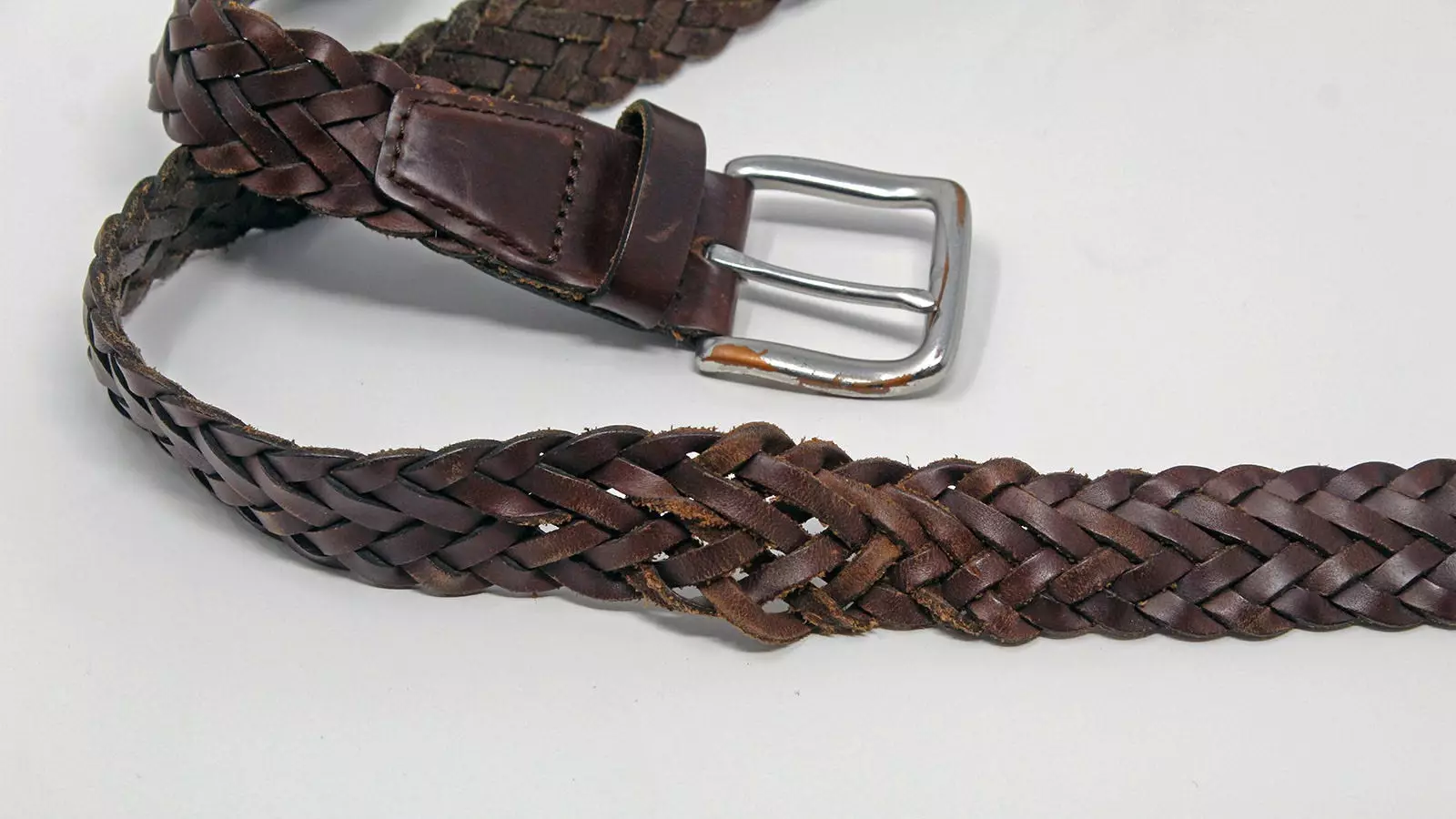 Una cintura intrecciata marrone con una sezione che mostra una trama più ampia.