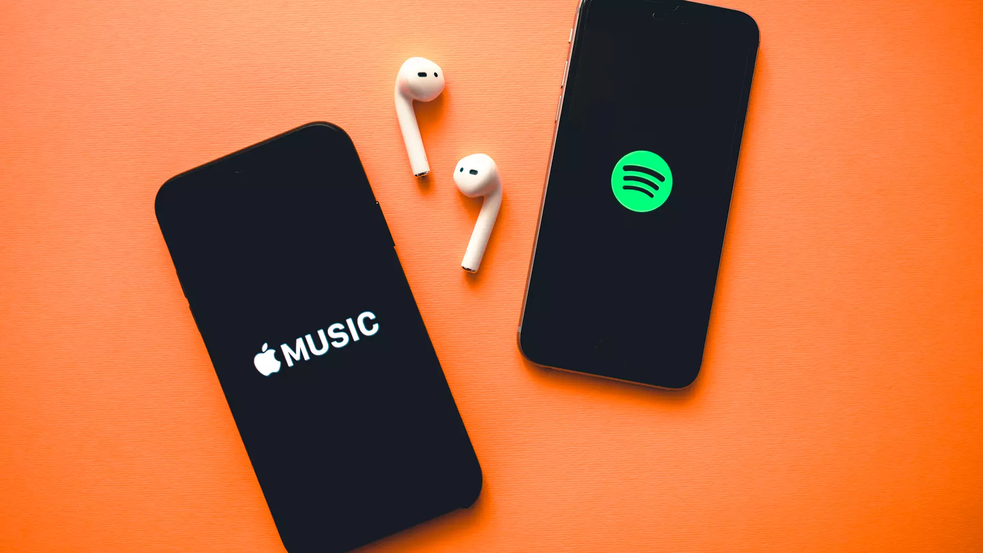 To telefoner viser Spotify- og Apple Music-logoerne.