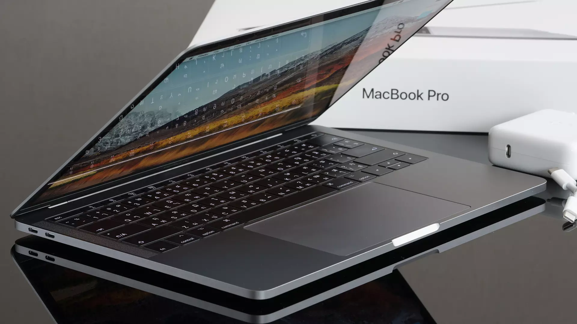 En MacBook Pro på et bord ved siden av boksen.