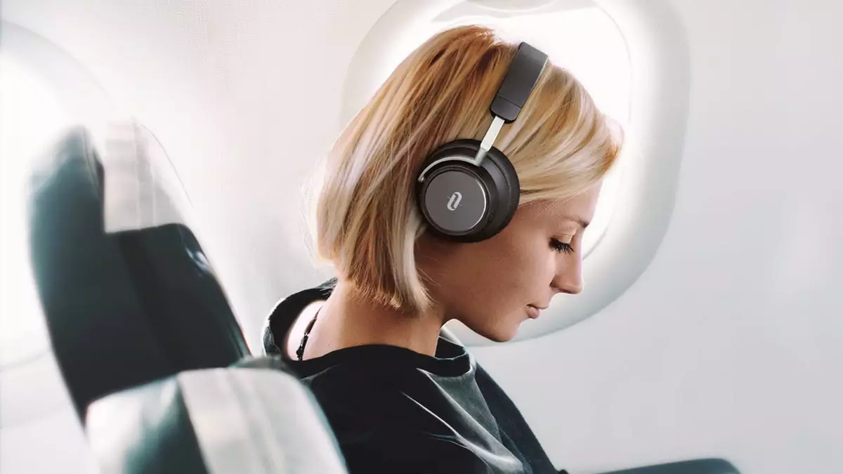 Taotronics ANC ヘッドフォンを装着して飛行機に座っている女性。