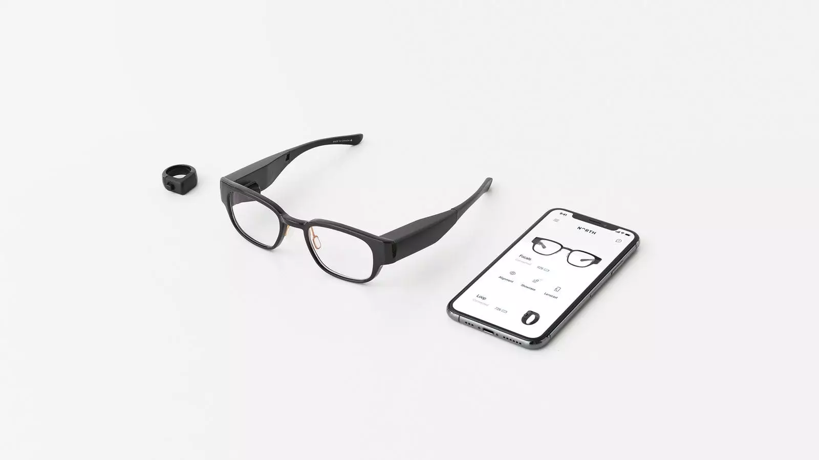 Sepasang kacamata pintar Focals, pengontrol dering, dan ponsel yang menampilkan aplikasi kacamata pintar.