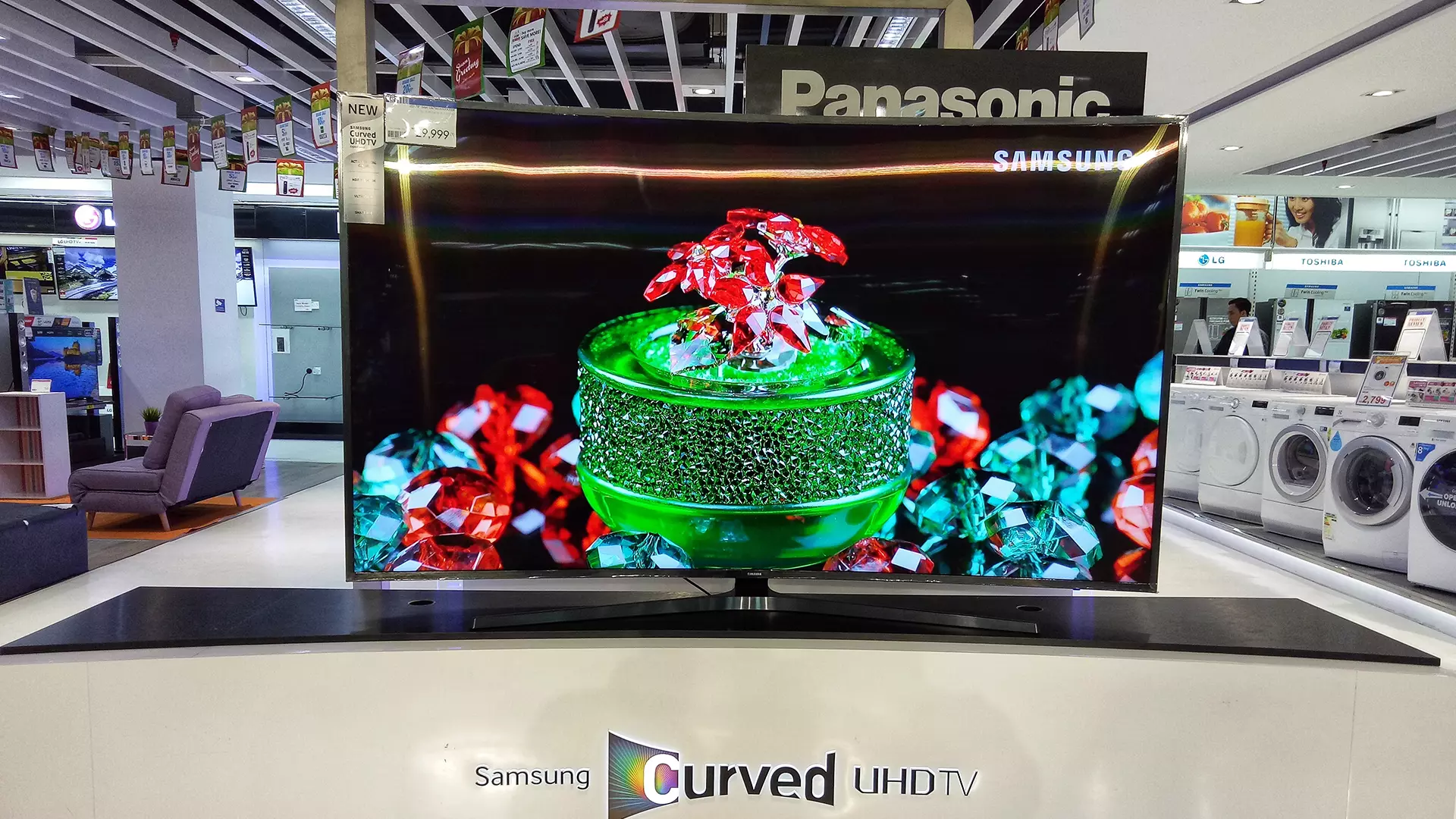 Uma TV Samsung curva no chão do showroom.