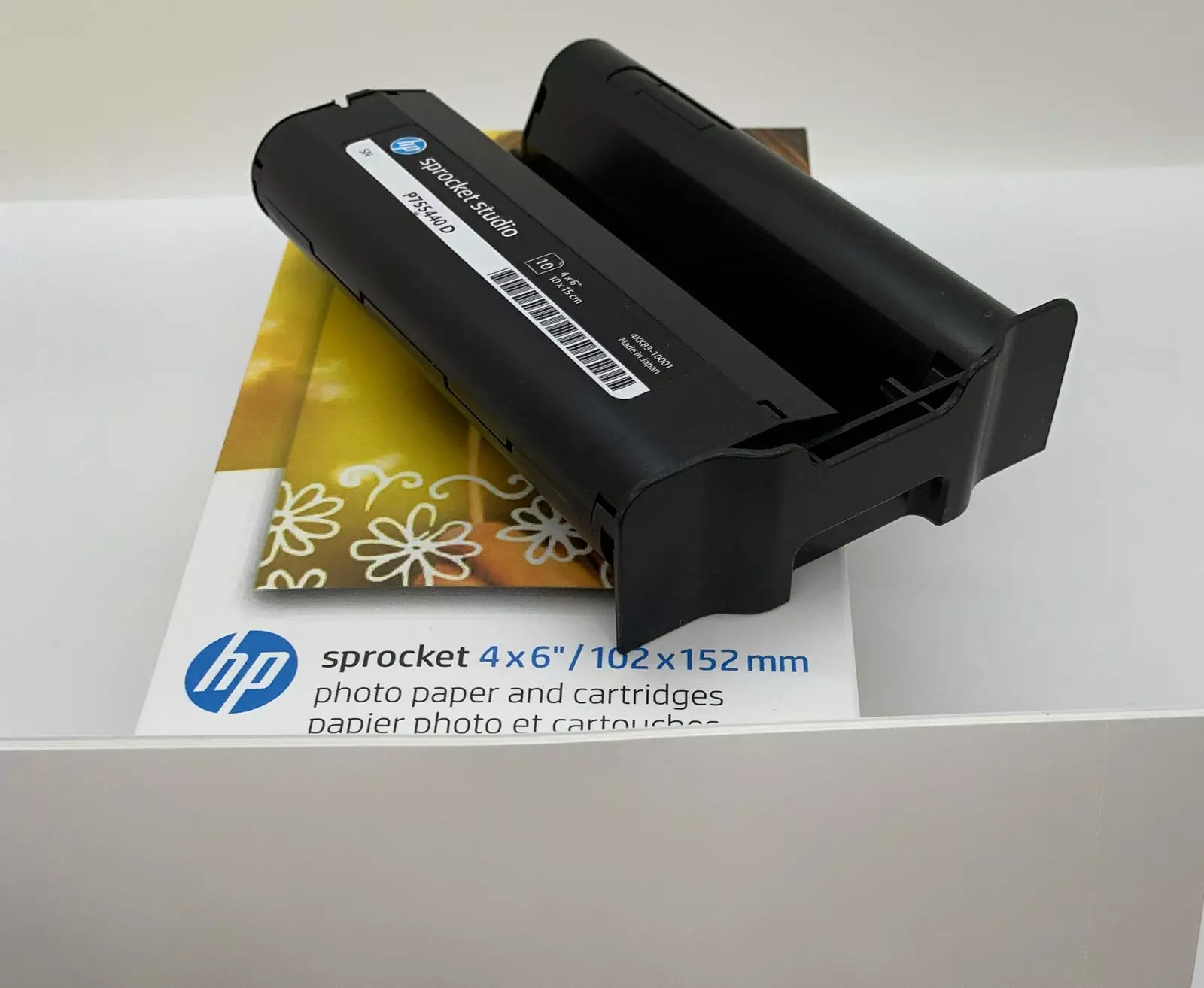 Páska Sprocket Studio Dye Sub na horní straně balení fotografického papíru HP.