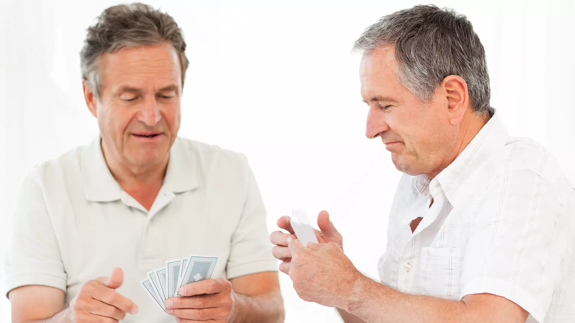 एक वृद्ध जोडपे कार्ड-आधारित बोर्ड गेम खेळत आहे