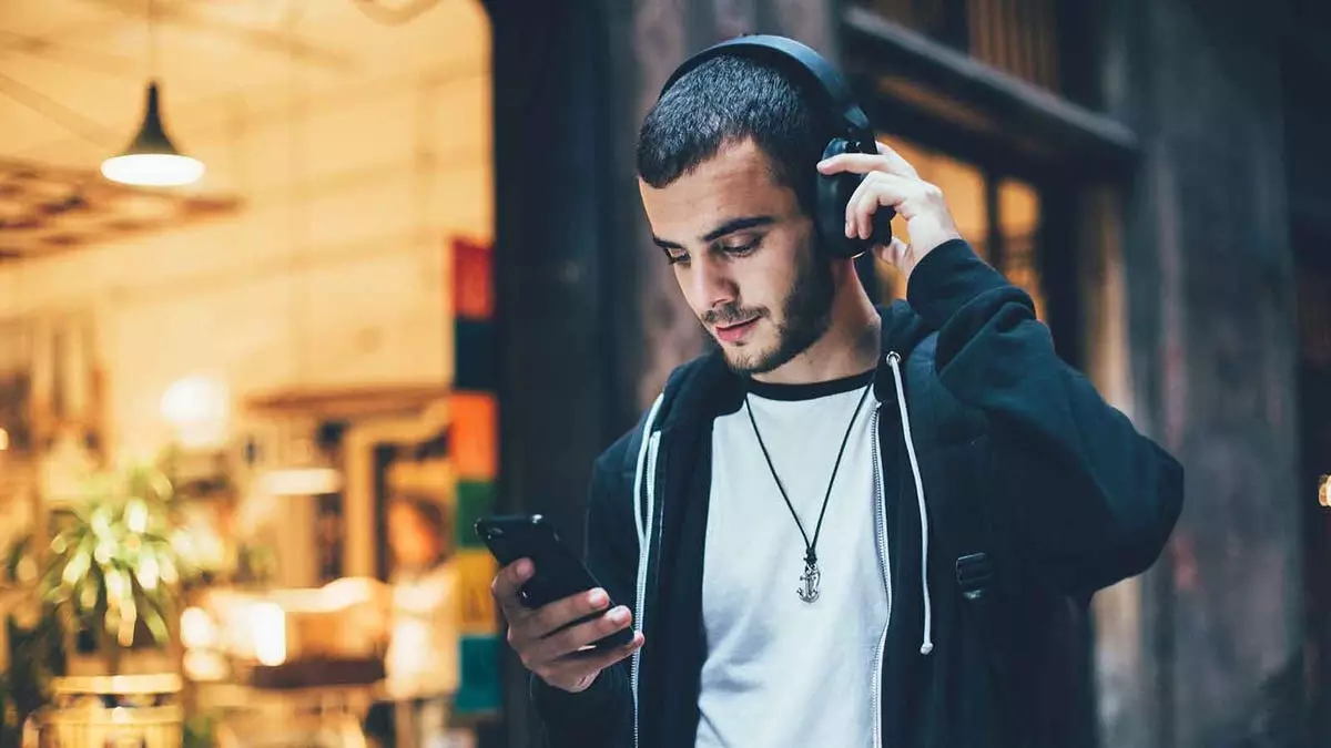 Čovjek sluša glazbu na ulici koristeći slušalice za suzbijanje buke