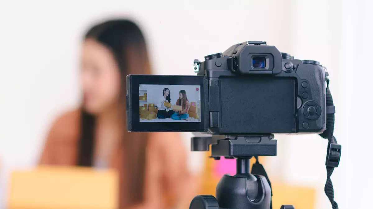 2 人の女性のインタビューを記録するデジタル ビデオ カメラ