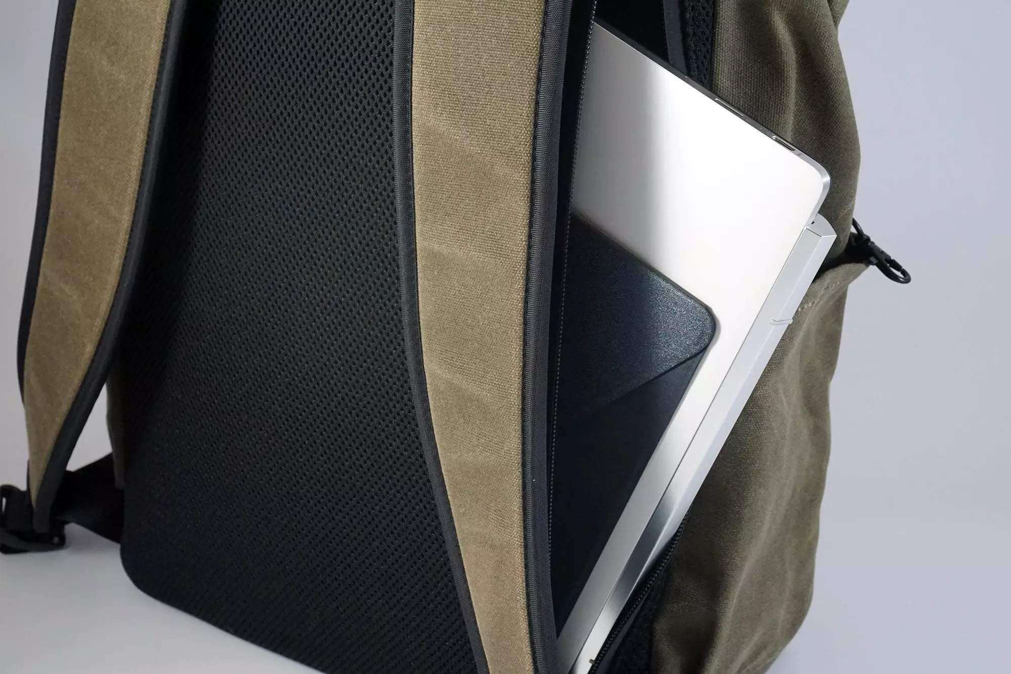 Um bolso resistente com zíper na parte de trás oferece fácil acesso a um laptop.