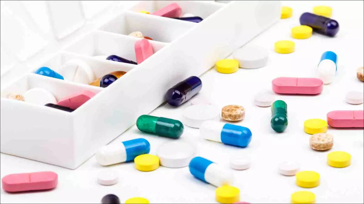 Pílulas coloridas e cápsulas dentro e fora do organizador de pílulas