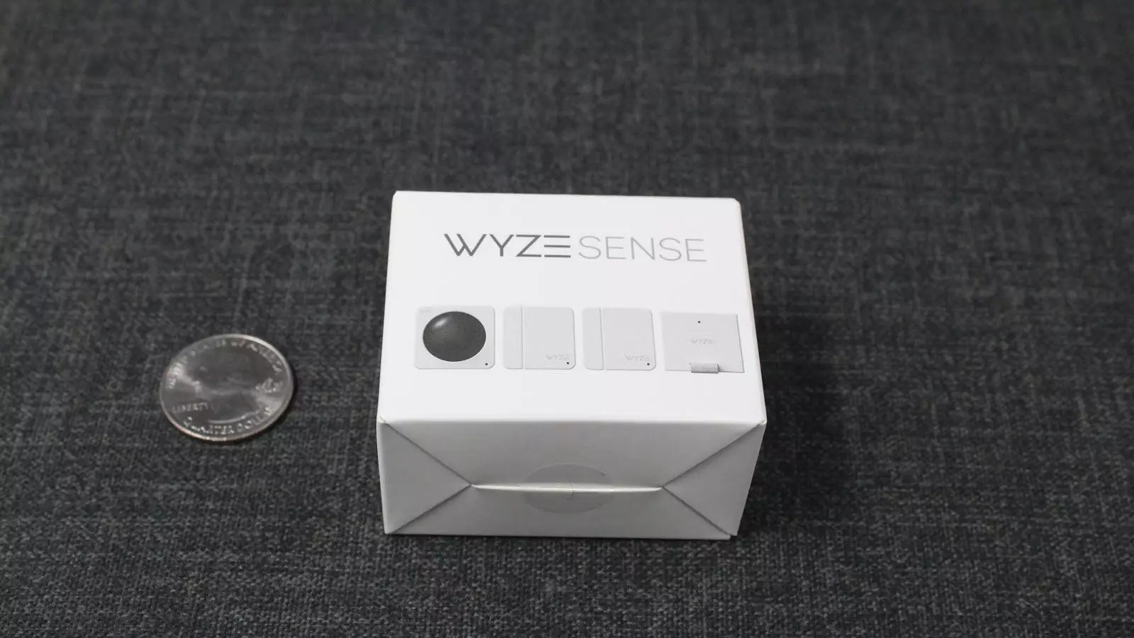 Wyze Sense box naast een kwartje, laat zien hoe klein het is.