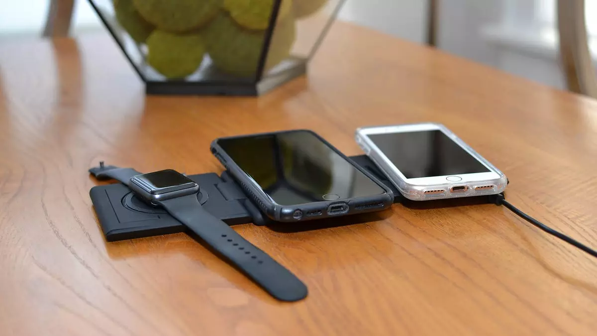 Un Apple Watch, iPhone 8 Plus y iPhone 8 en un cargador Unravel